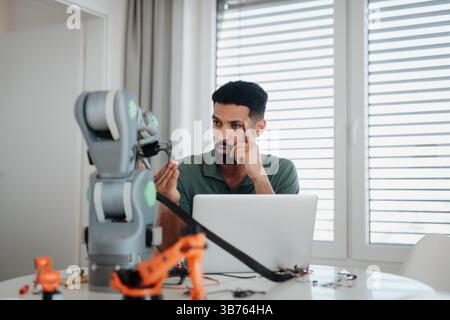 Engineer struggling with a technical problem while building robotic arm ...
