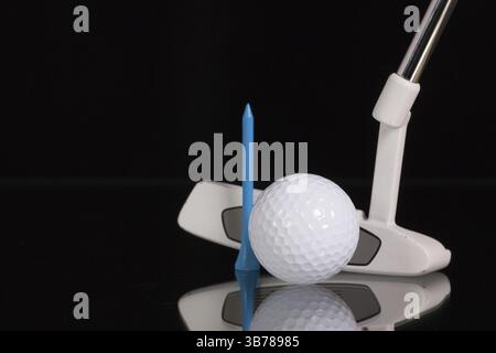 Golf putter and different golf equipments on the black glass desk Stock ...