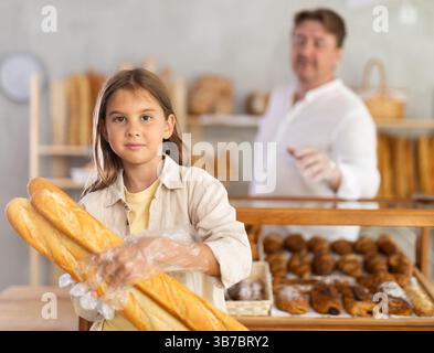 Girl in bakery chooses bread, considers various product options Stock ...