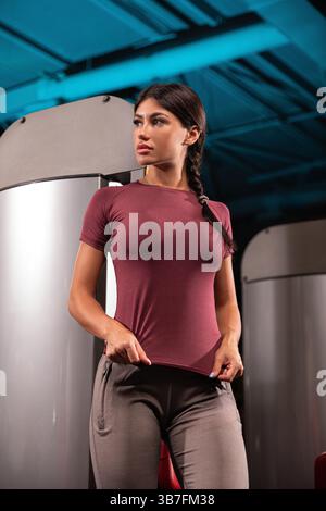 A sporty female model poses confidently in a studio, wearing a stylish ...