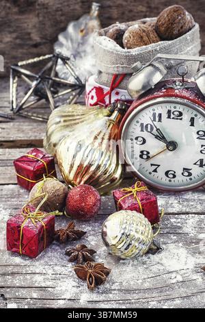 Alarm clock with festive decorations on blue background. Christmas ...