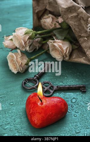 Burning candle and bouquet of roses in neon light, valentine's day ...