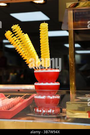 Cooking spiral fried potato in boiling oil, rich in fat and calories ...