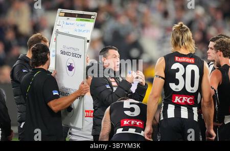 Coach Craig McRae and Collingwood AFL players pose for a team photo at ...