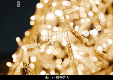 The festive garland glows with blurred bokeh and a flowerpot with a ...