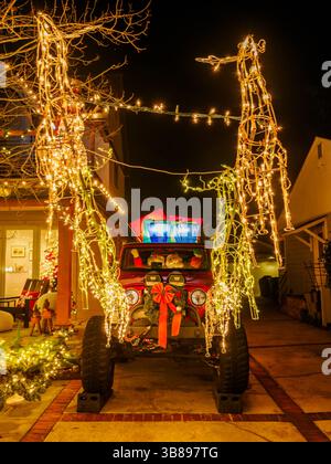 Glowing Christmas tree with presents and wreath on red wall Stock Photo ...