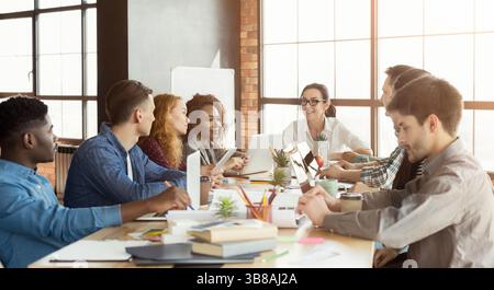a group of young graphic designers working on a digital tablet and a ...