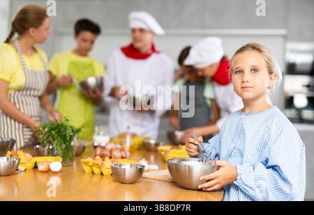 Interested tween girl attending group culinary classes for children ...