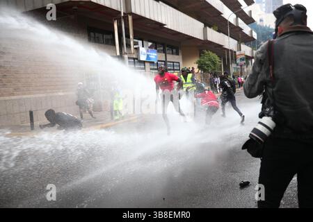 Demonstrators are sprayed by a police water cannon during an anti ...