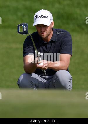 Wyndham Clark lines up a putt on the first hole during the final round ...