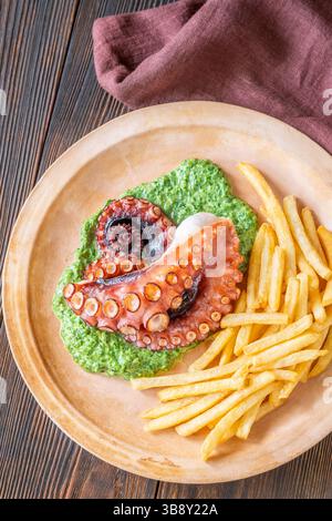 Roasted octopus tentacles served with creamy spinach and golden fries ...