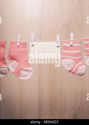 Baby girl socks attached to the rope Stock Photo - Alamy