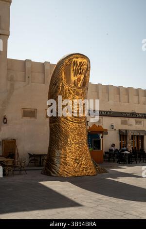 The Golden Thumb Statue, Souq Waqif, Doha, Qatar, with the Fanar Qatar ...