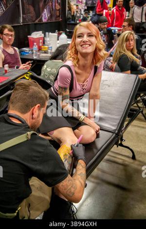 Men look at images of tattoos on a TV screen at the Hipnosis Invita ...