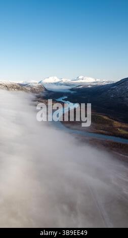 An aerial shot of the river and a road surrounded by autumn trees with ...