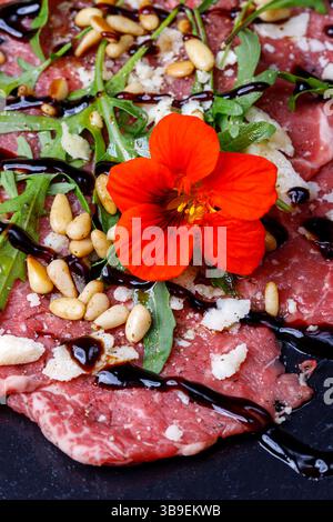 Fresh carpaccio with rocket on slate Stock Photo - Alamy