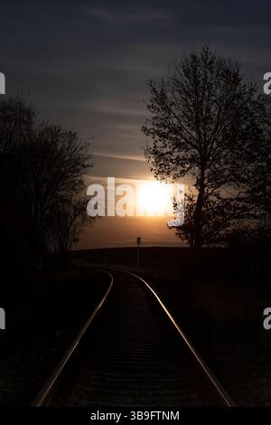 Rising full moon over a single-track railroad line Stock Photo - Alamy