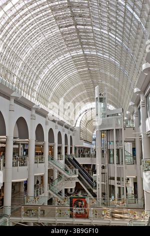 Large shopping center with multiple levels of shops and escalators ...