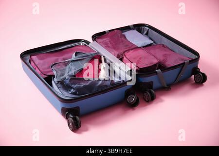 Open suitcase with packing cubes on light grey background, above view ...
