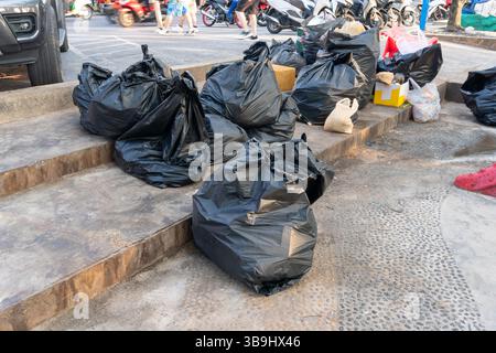 Garbage bags on footpath in city Stock Photo - Alamy