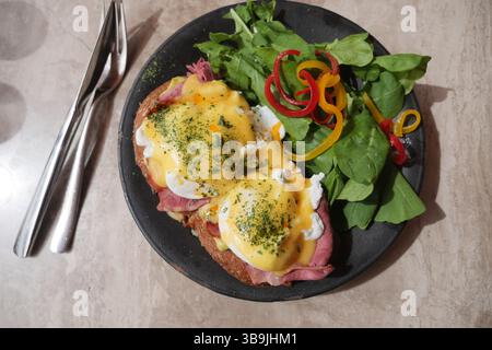 Delicious Eggs Benedict Served With Fresh Greens in a Cozy Cafe Setting ...