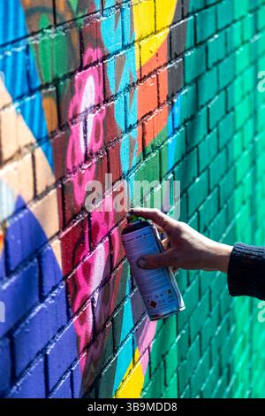 Artist Louis Masai working on a mural for Hit the North Translink ...