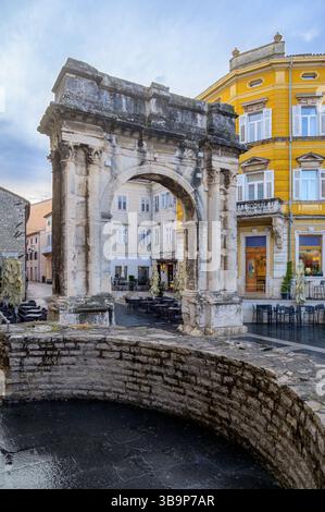 Visitors admire the ancient Roman Gate in Pula, Croatia, as the sun ...