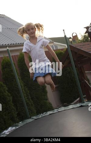 Playful girl jumping on trampoline at park Stock Photo - Alamy