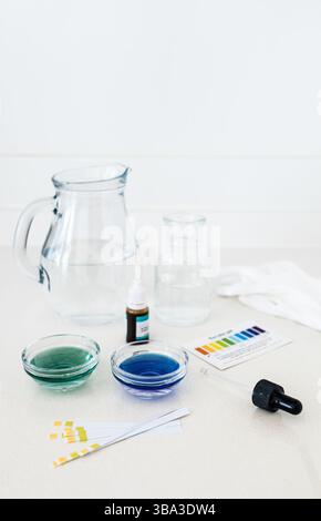 Photographs of a water pH testing kit including color indicator drops ...