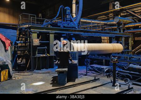 Factory engineer operates pipe painting automatic machine Stock Photo ...