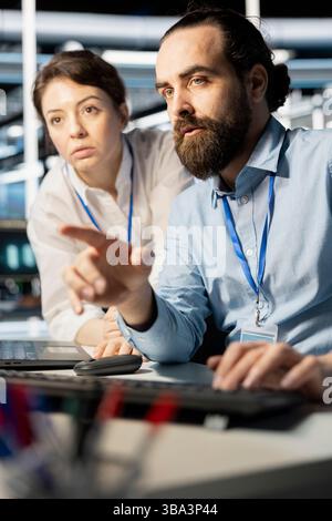 Programmers doing brainstorming in server room, reviewing neural ...
