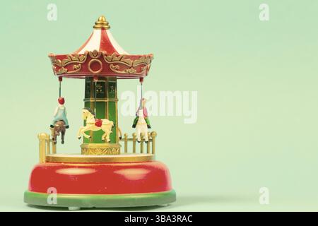 Vintage toy carousel on an emerald background. Red carillon with ...