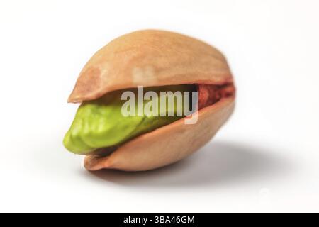 Single red Turkish pistachio, green nut visible under shell, isolated ...