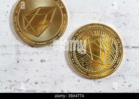 Close up shot of a golden EOS digital cryptocurrency, front and back ...