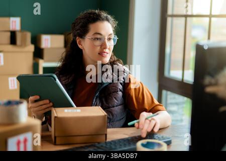Female inventory manager checking stock. Woman working in a warehouse ...