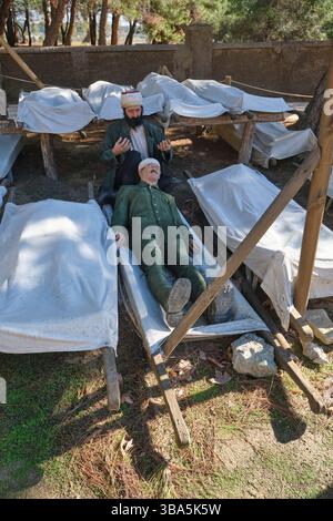 An Imam, priest, praying over an injured soldier on a stretcher among ...