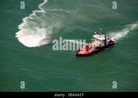 An aerial photo of a ship dredging an inlet Stock Photo - Alamy