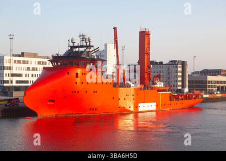 Offshore supply vessel moored at industrial port terminal with yellow ...