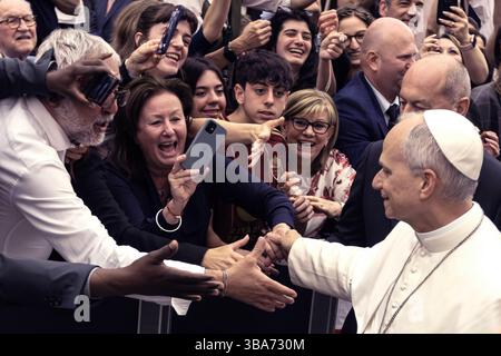 Pope Leo XIV shakes hands with Monsignor Rino Fisichella, right, as he ...