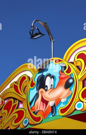 A colourful fairground ride header panel with portraits of well known ...