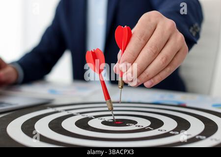 Man with dart aiming at dartboard while working indoors, closeup Stock ...