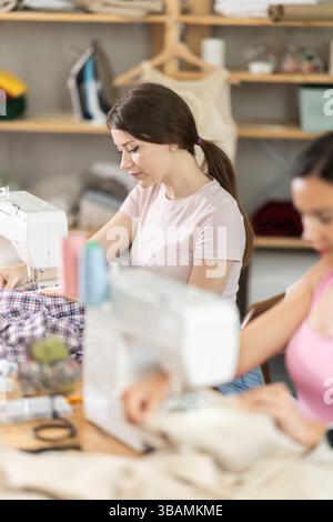 Two women tailor sews clothes in sewing machine Stock Photo - Alamy
