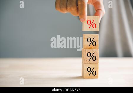 Businessman's hand arranging a wood cube block with a percentage symbol ...