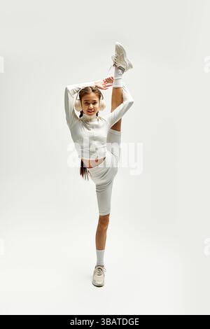 Athletic girl in sportswear performs exercises with a barbell ...