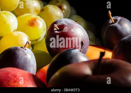 plum fruit mix on black background Stock Photo - Alamy