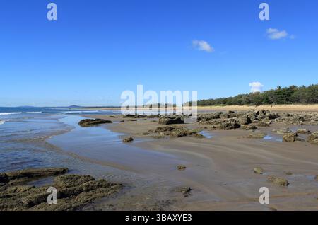 Sand, rocks and the ocean at Tannum Sands beach in Queensland ...