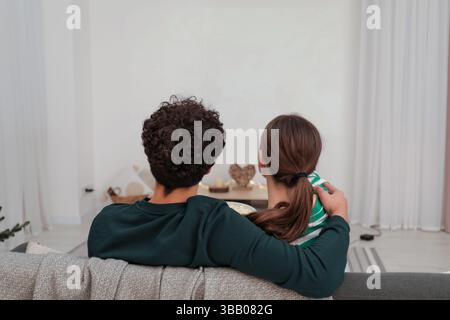 Couple watching movie via video projector at home, back view Stock ...