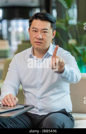 Portrait of mature businessman shakes finger and saying No be careful ...