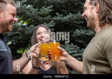Friends celebrating and cheering with beer pints for National Beer ...