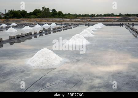 Salt mounds form in evaporation pools near Asian village using natural ...